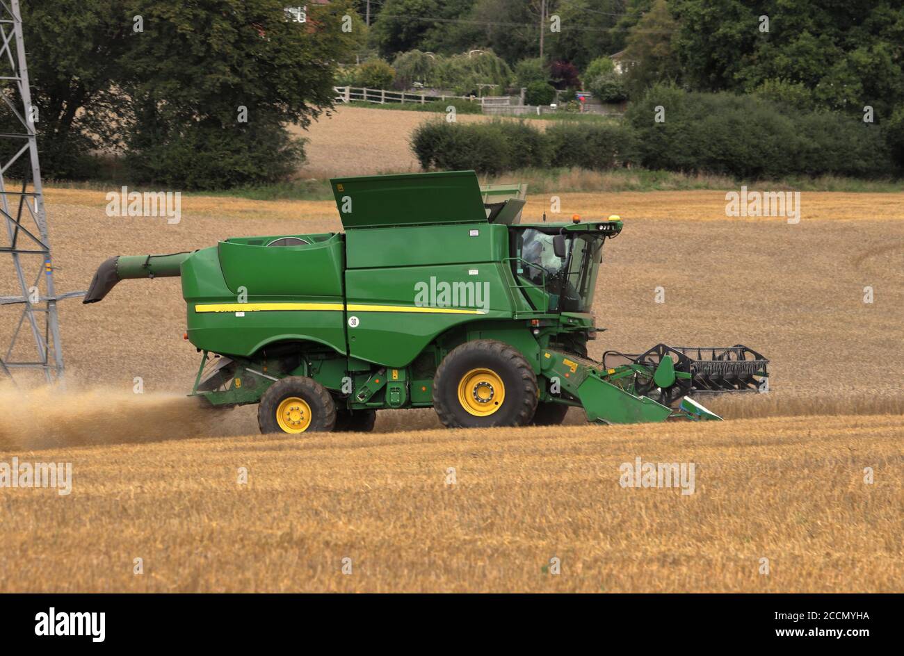 Combine Harvester cutting Wheat in a field in rural england, with Stock ...