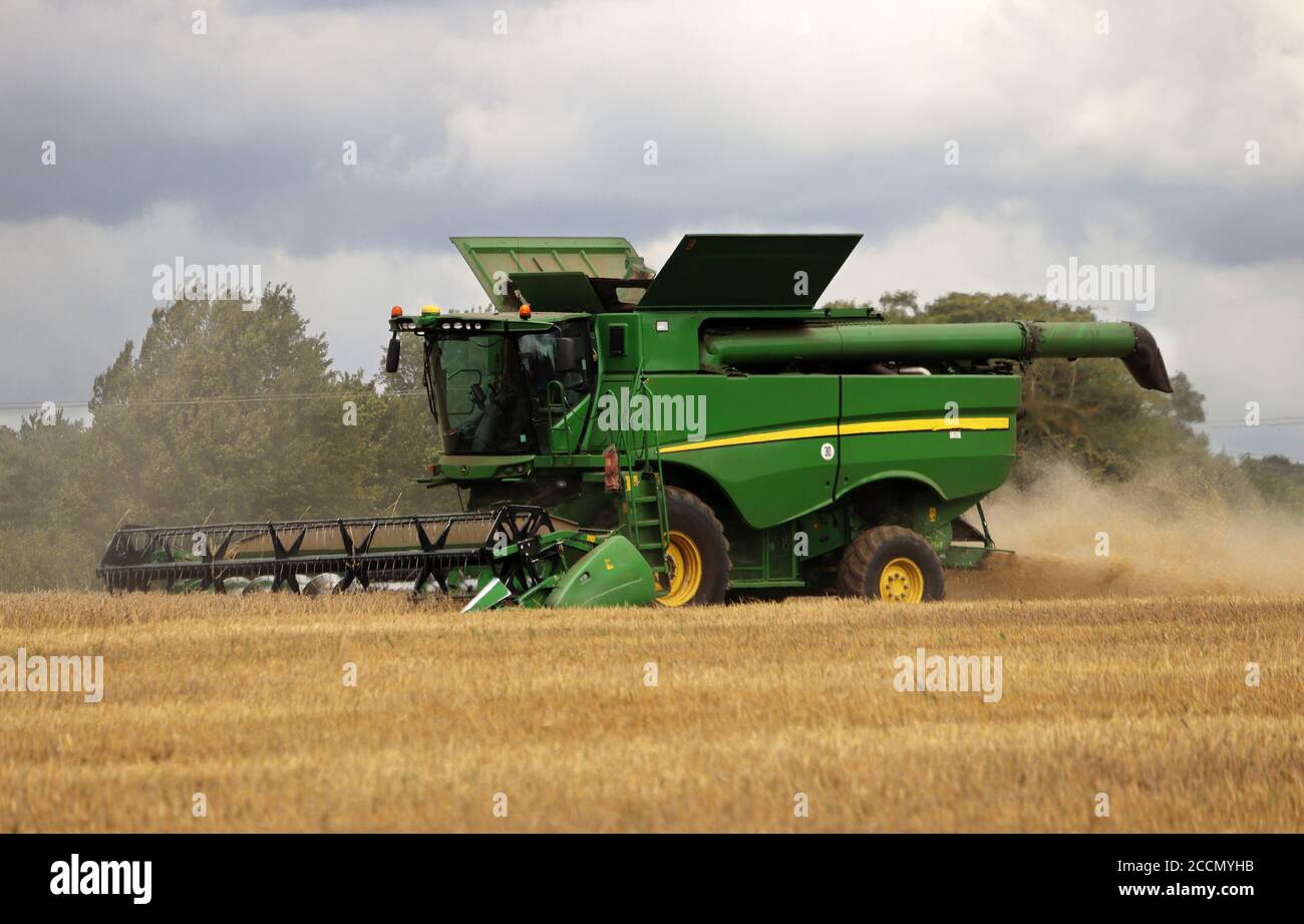 Combine Harvester cutting Wheat in a field in rural england, with Stock ...