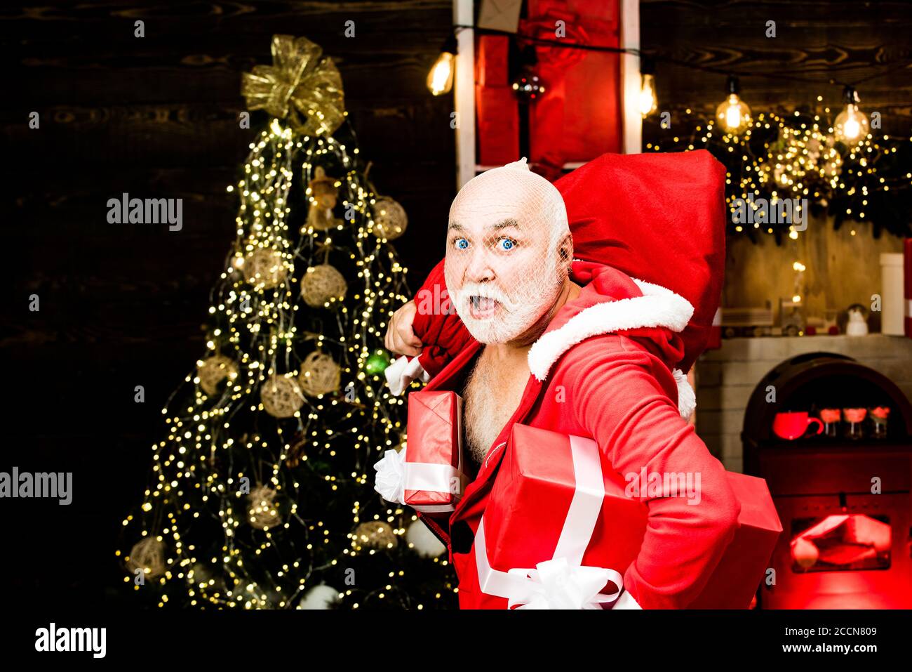 Burglar man dressed in Santa wearing a Santa hat. Thief Santa with bag ...