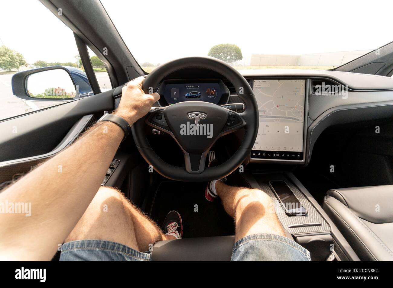 Person driving a new Tesla SUV. The interior of a full-sized, all ...