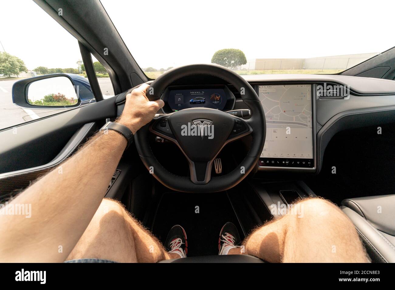 Person driving a new Tesla SUV. The interior of a full-sized, all ...
