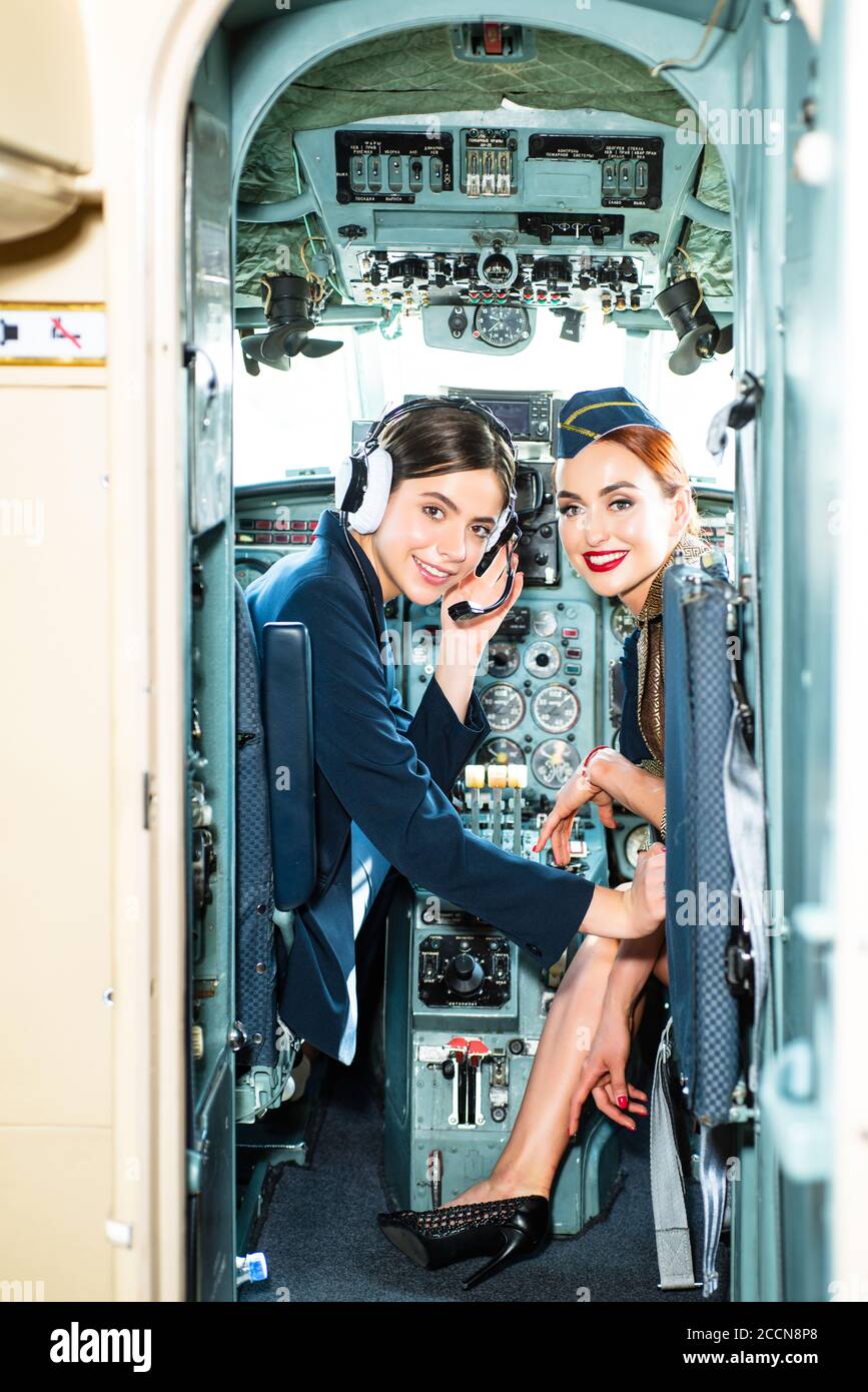 Two young girls in aircraft. Young Woman Pilot With Headset. Beautiful ...