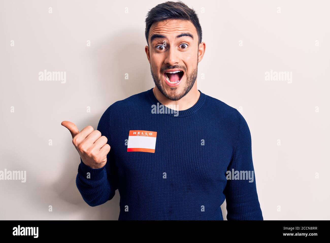 Young handsome man with beard wearing identification sticker over ...
