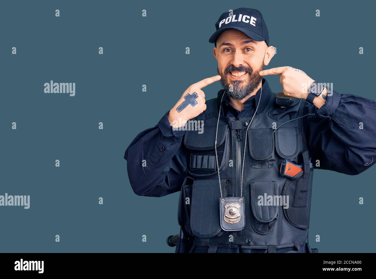 Young handsome man wearing police uniform smiling cheerful showing and ...