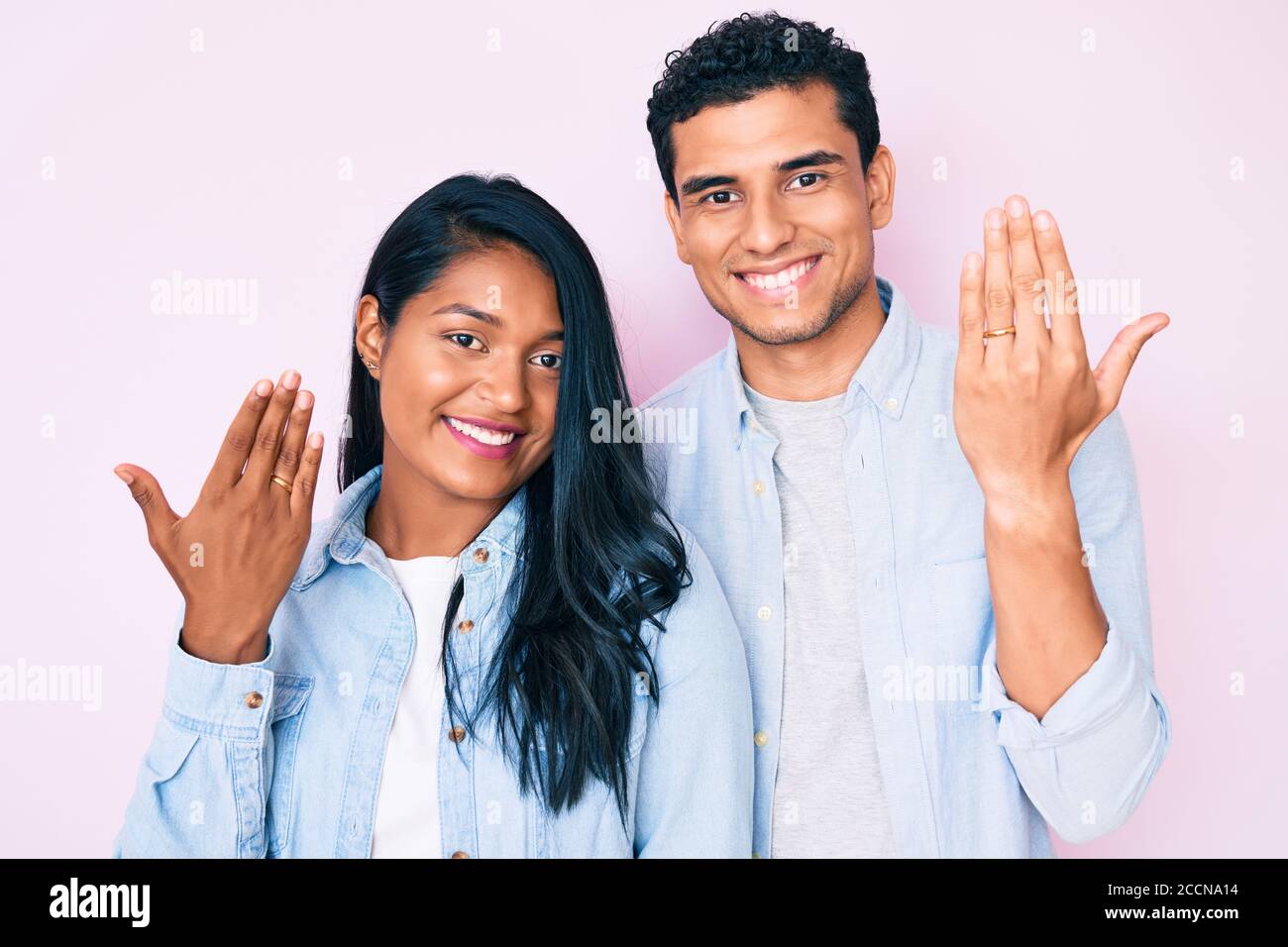 Beautiful latin young couple wearing engagement ring looking positive ...