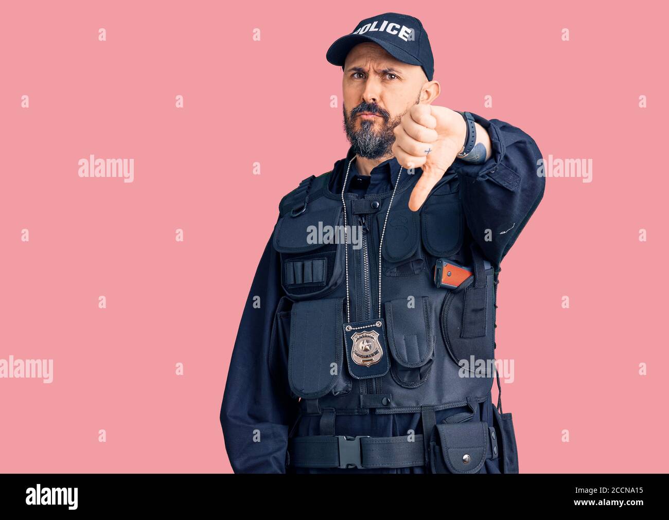 Young handsome man wearing police uniform looking unhappy and angry ...