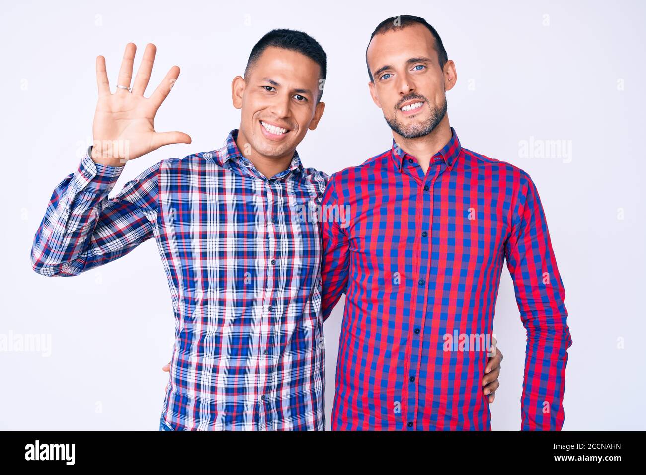 Young gay couple of two men wearing casual clothes showing and pointing ...