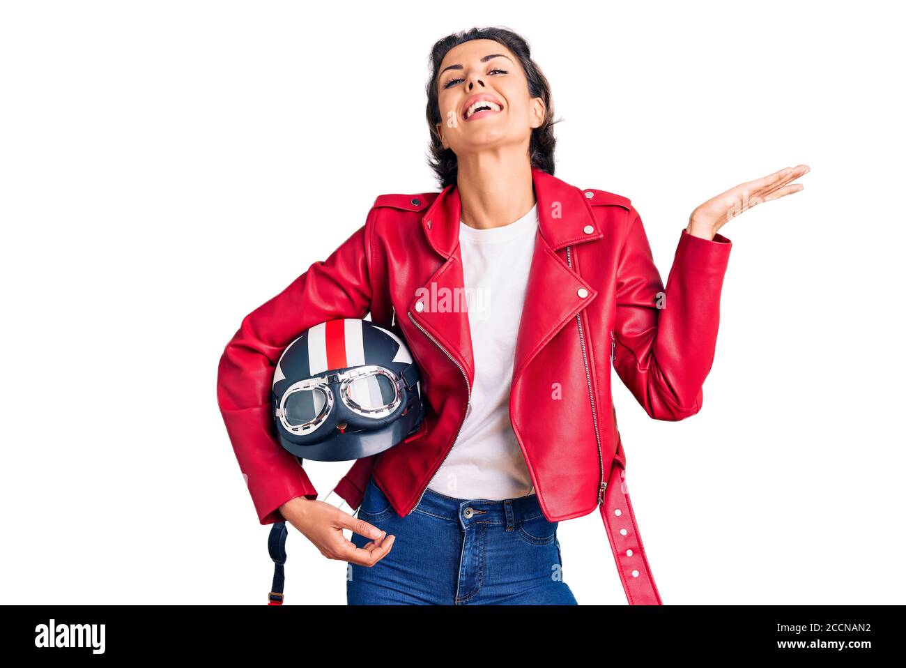 Young beautiful woman holding motorcycle helmet celebrating victory ...