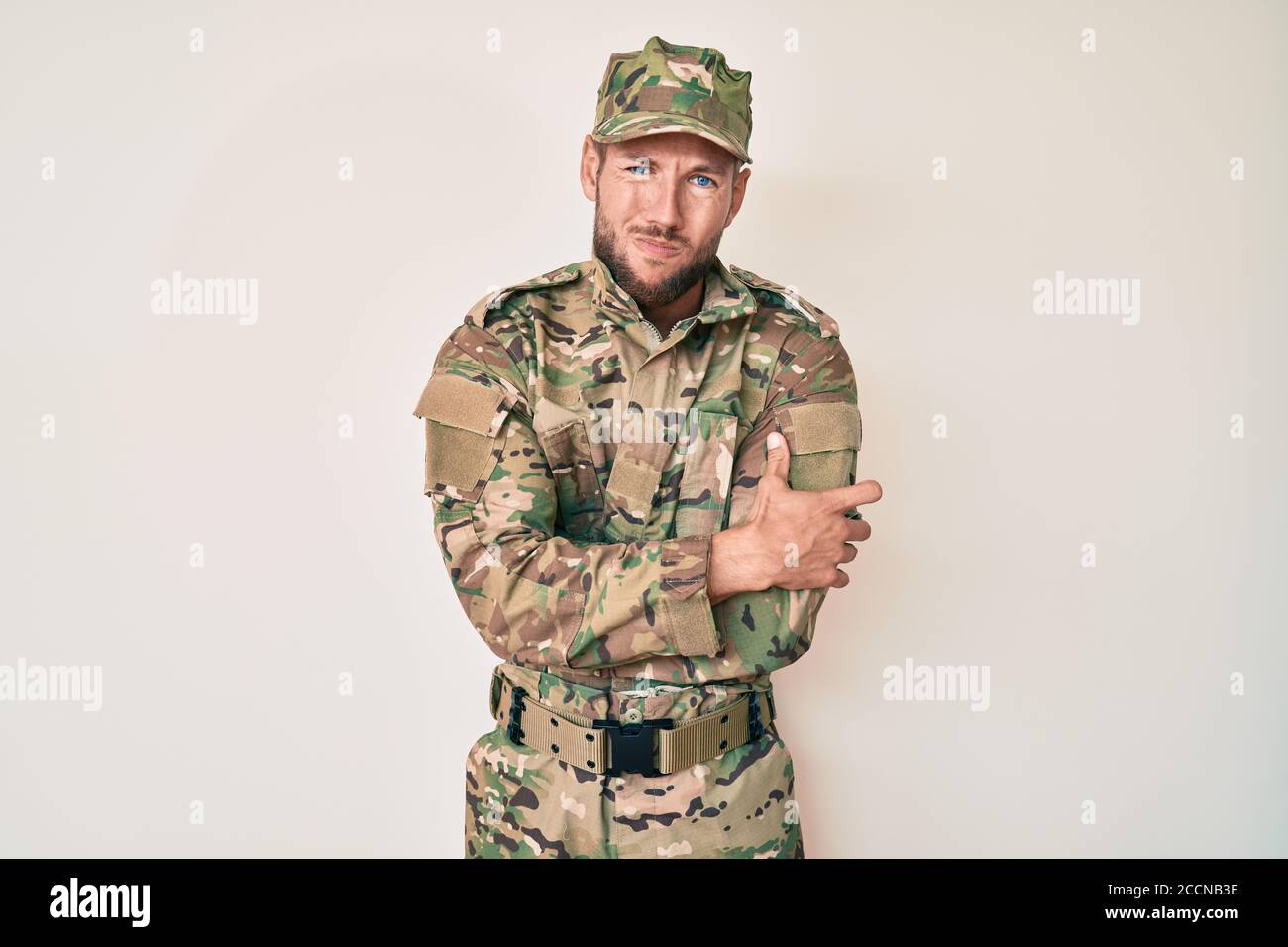 Young caucasian man wearing camouflage army uniform shaking and ...