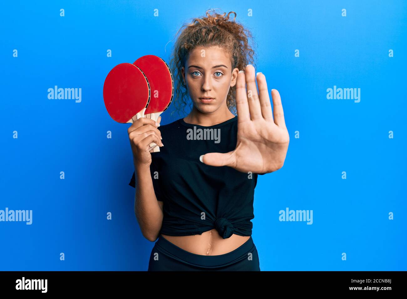 Beautiful caucasian teenager girl holding red ping pong rackets with ...