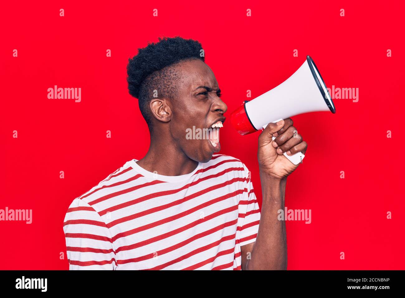 Young african man shouting angry throught megaphone Stock Photo - Alamy