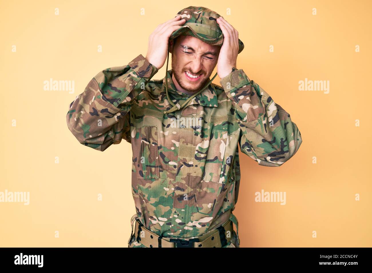 Young caucasian man wearing camouflage army uniform suffering from ...