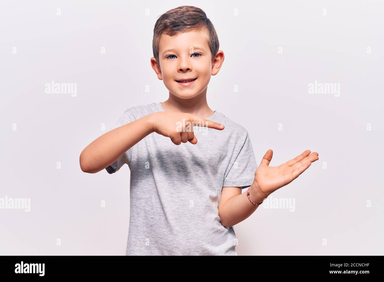Cute blond kid wearing casual clothes amazed and smiling to the camera ...