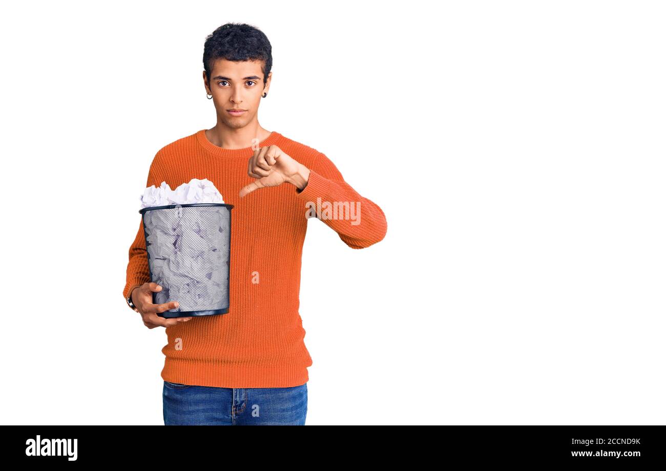 Young african amercian man holding paper bin full of crumpled papers ...