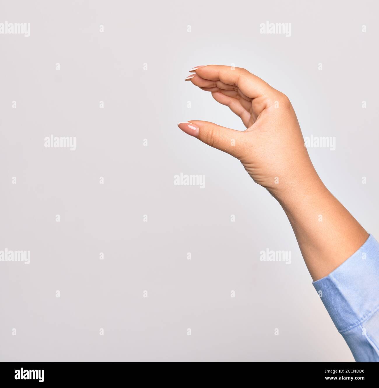 Hand of caucasian young woman doing catch sign over isolated white ...