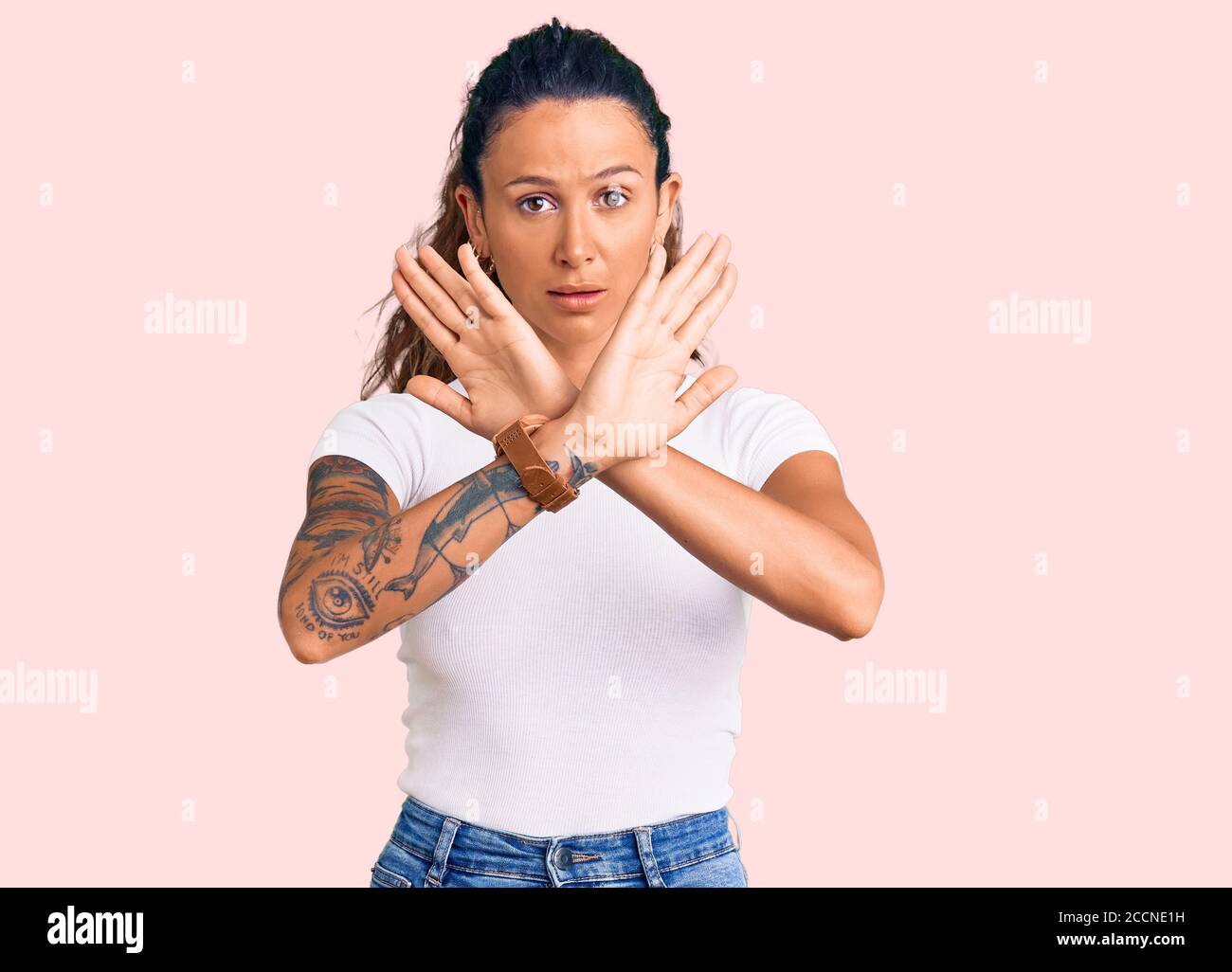 Young hispanic woman with tattoo wearing casual white tshirt rejection ...