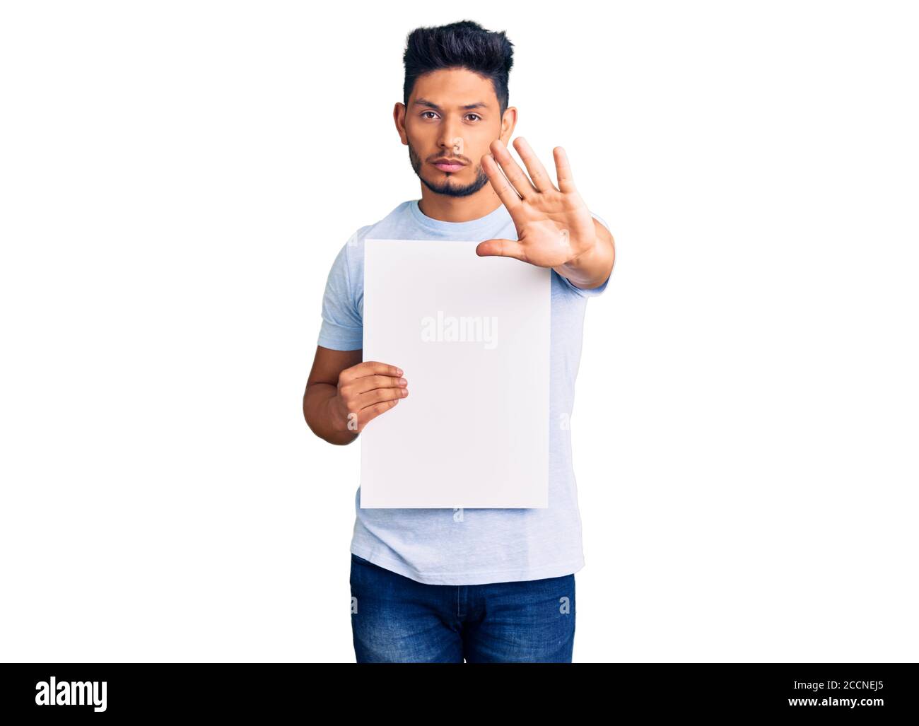 Handsome latin american young man holding cardboard banner with blank ...