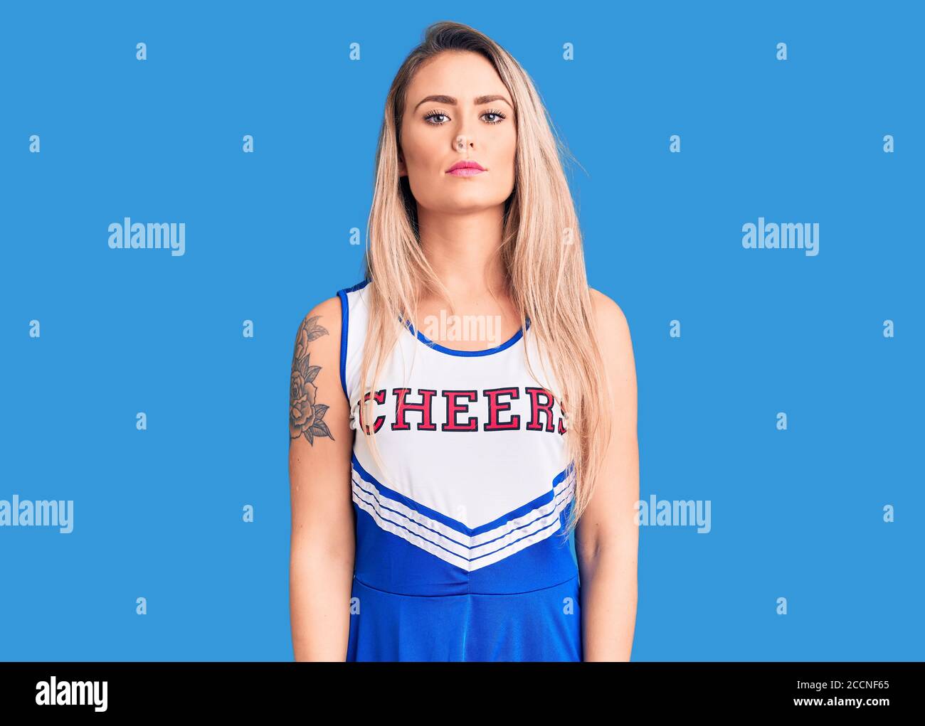 Young beautiful blonde woman wearing cheerleader uniform relaxed with ...