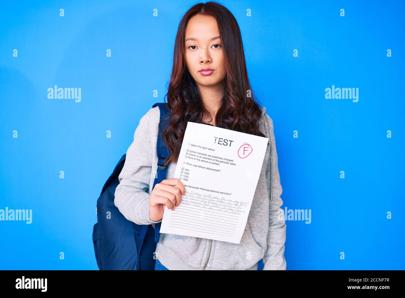 Young beautiful chinese girl showing a failed exam thinking attitude ...