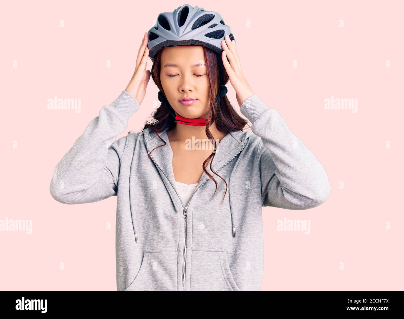 Young beautiful chinese girl wearing bike helmet suffering from ...