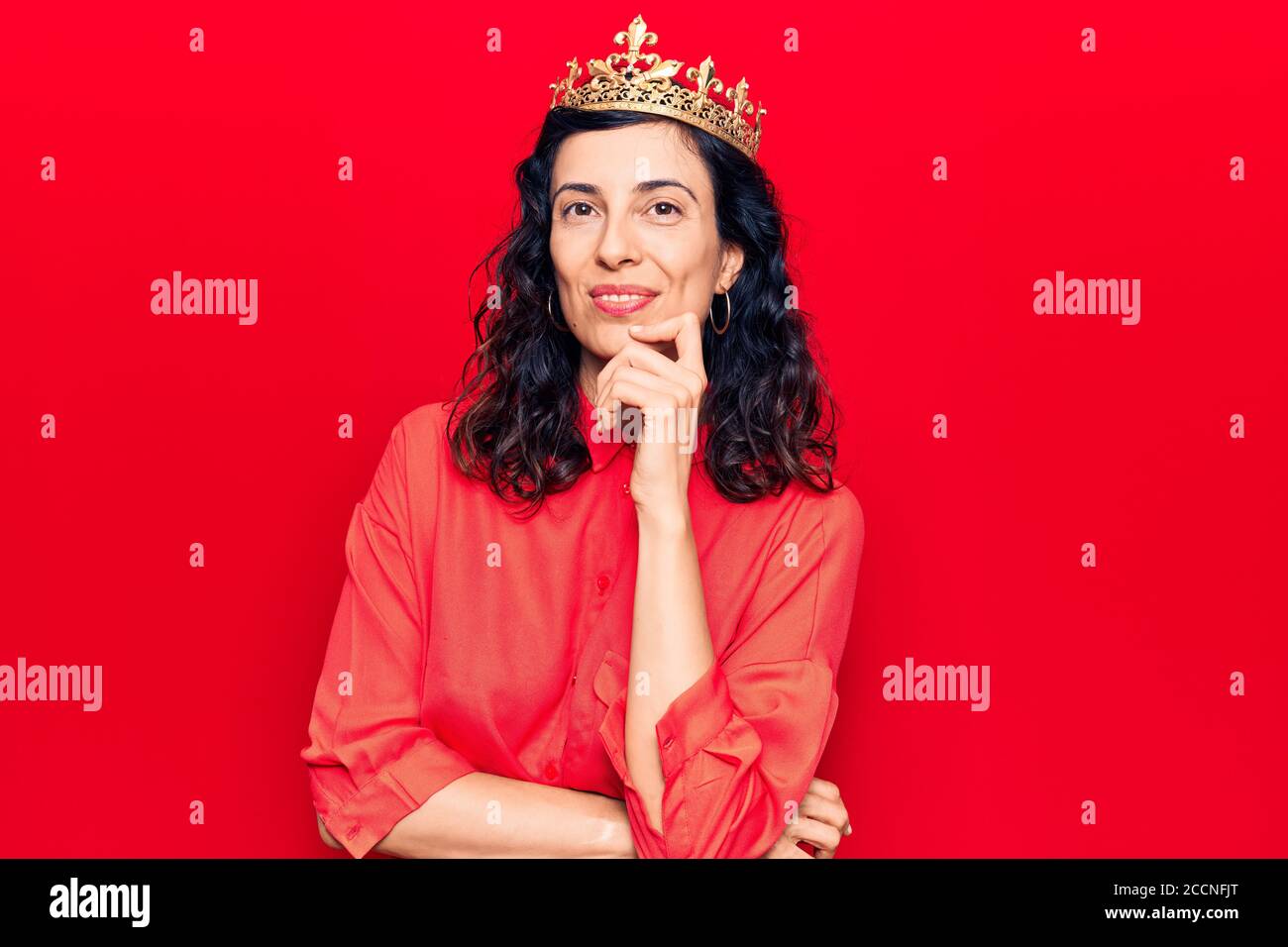Young beautiful hispanic woman wearing princess crown smiling looking ...