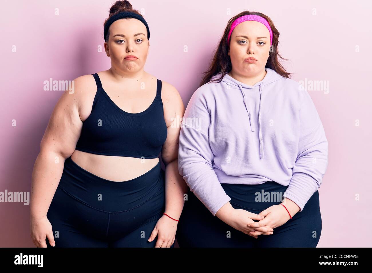 Young plus size twins wearing sportswear depressed and worry for ...
