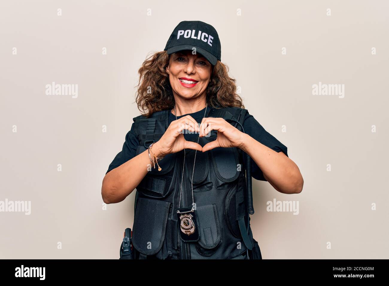 Middle age beautiful policewoman wearing bulletproof uniform and cap ...