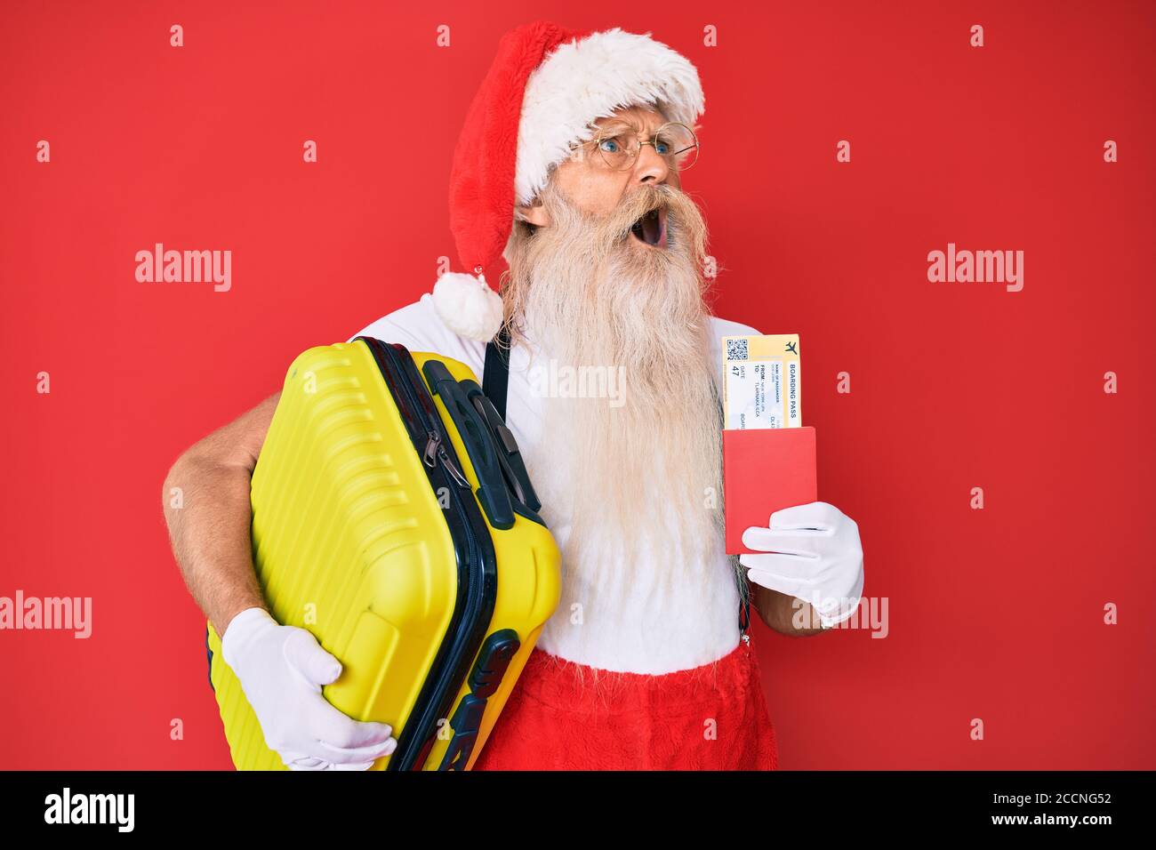 Old senior man wearing santa claus costume holding suicase and boarding ...