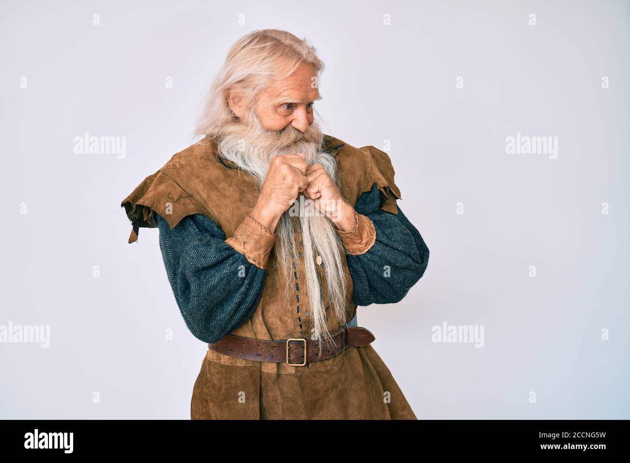 Old senior man with grey hair and long beard wearing viking traditional ...