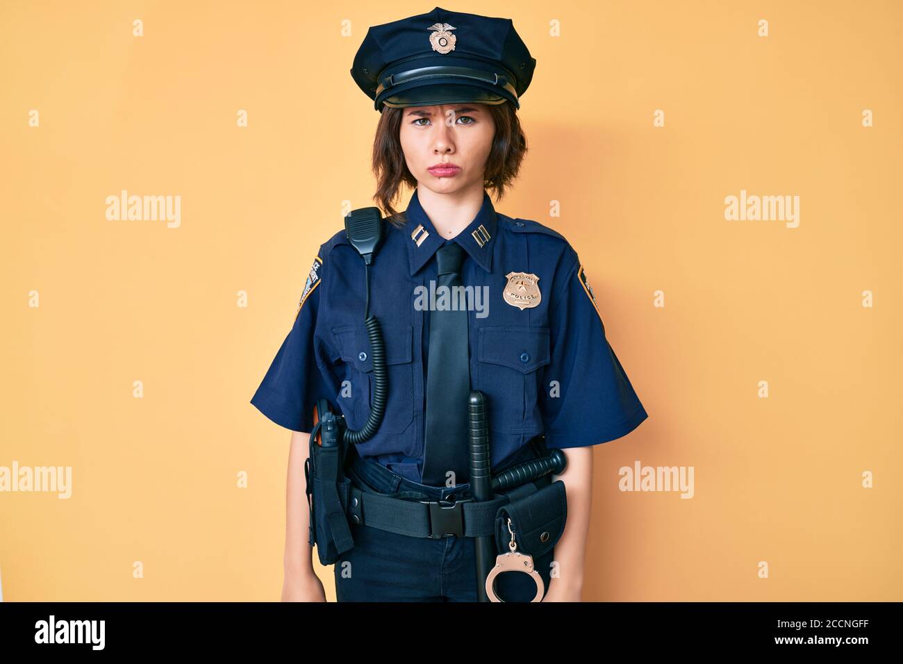 Young beautiful woman wearing police uniform skeptic and nervous ...