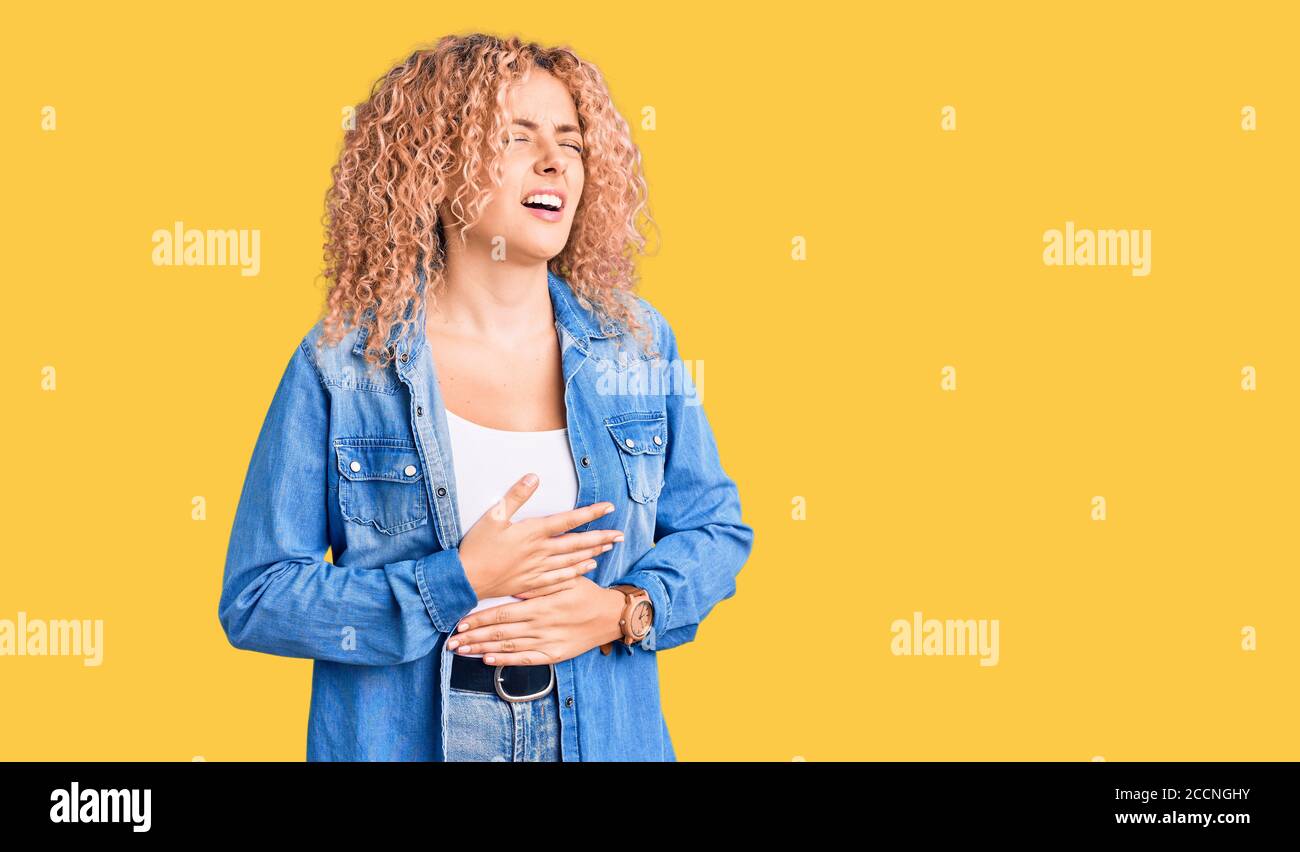 Young blonde woman with curly hair wearing casual denim jacket with ...