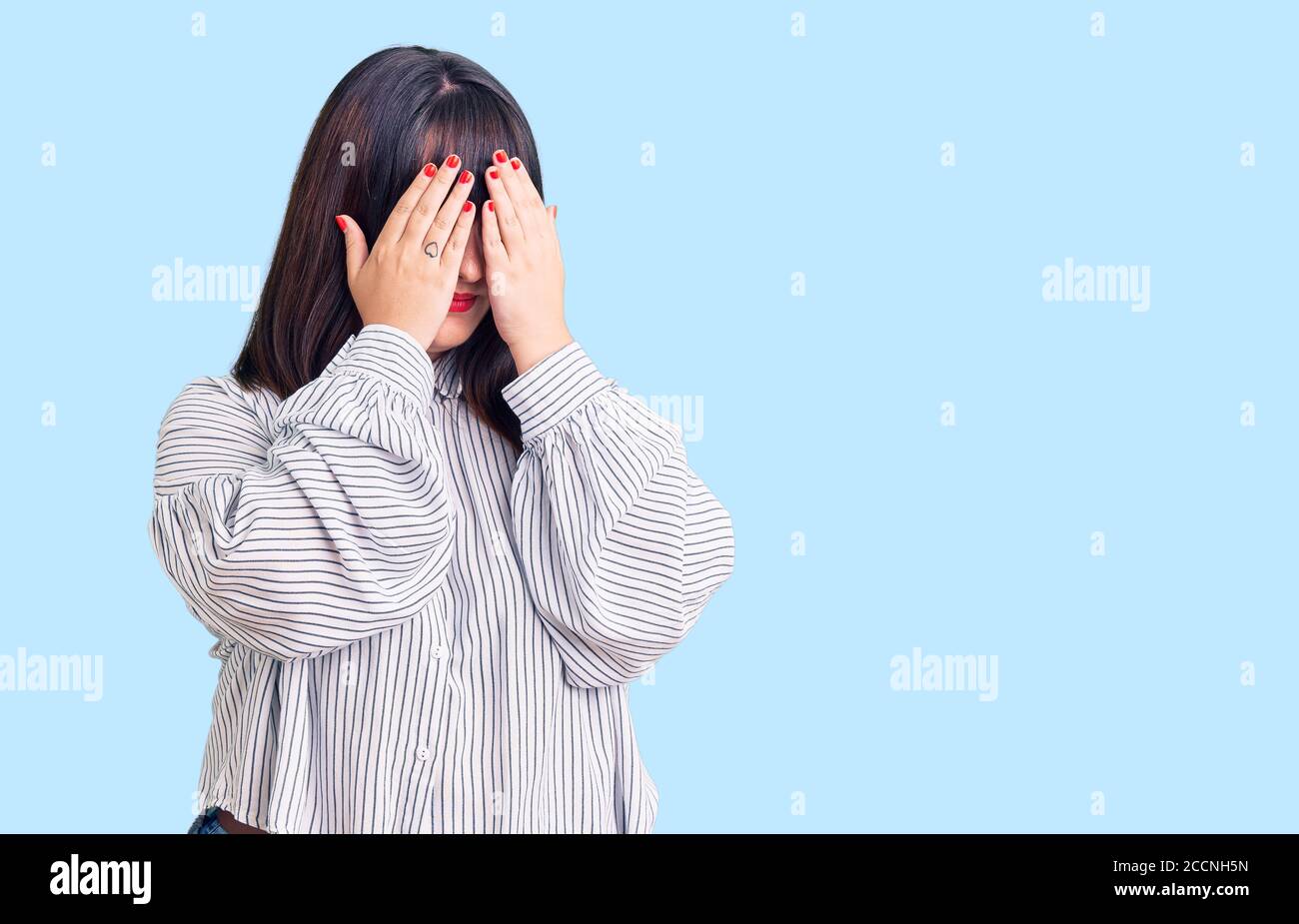 Young plus size woman wearing casual clothes with sad expression ...