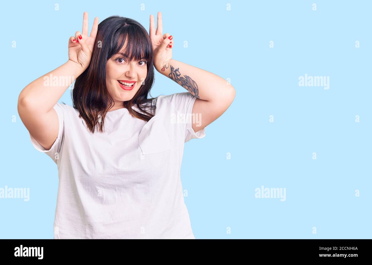 Young plus size woman wearing casual clothes posing funny and crazy ...