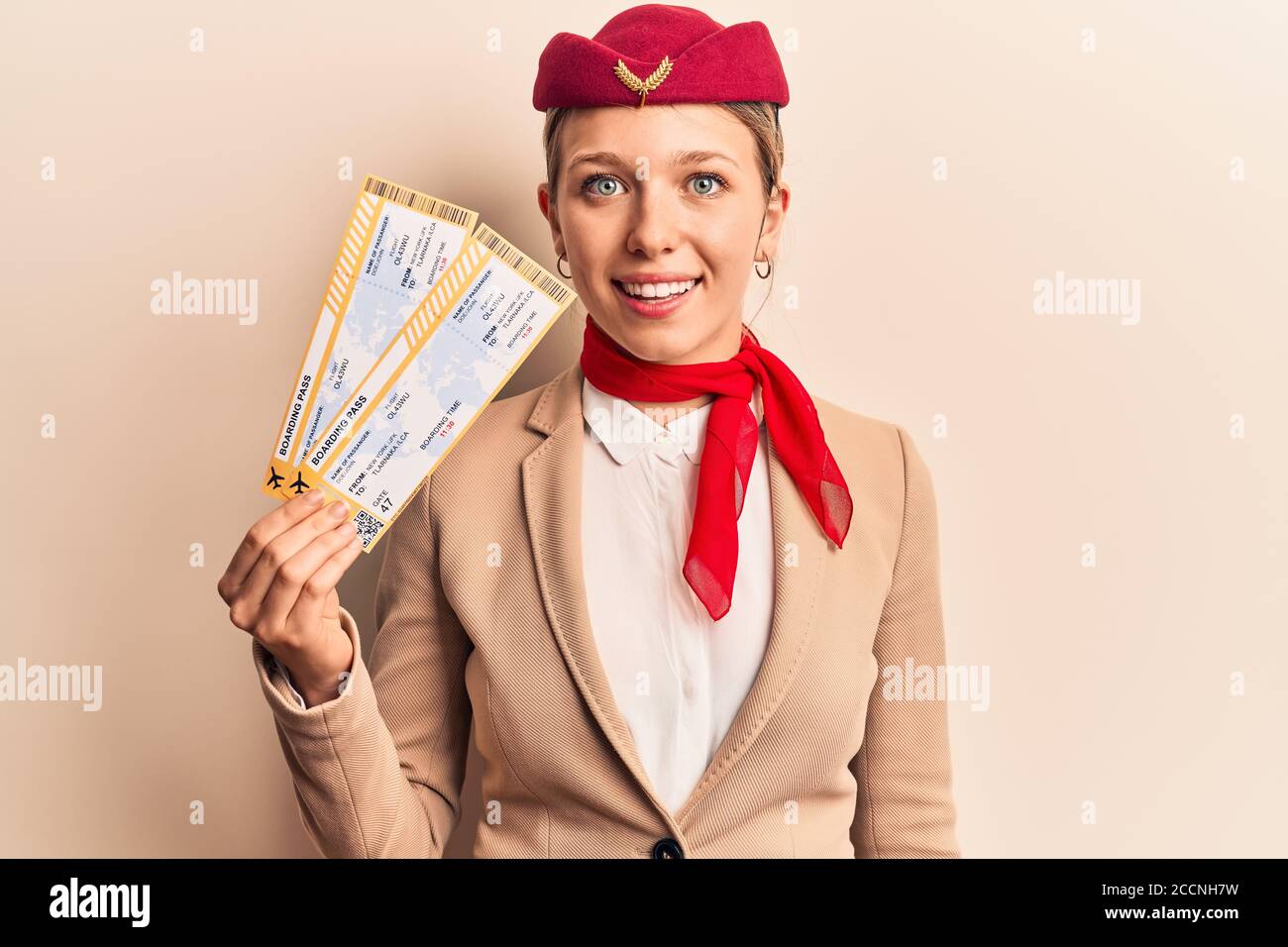 Young beautiful blonde girl wearing stewardess uniform holding boarding ...