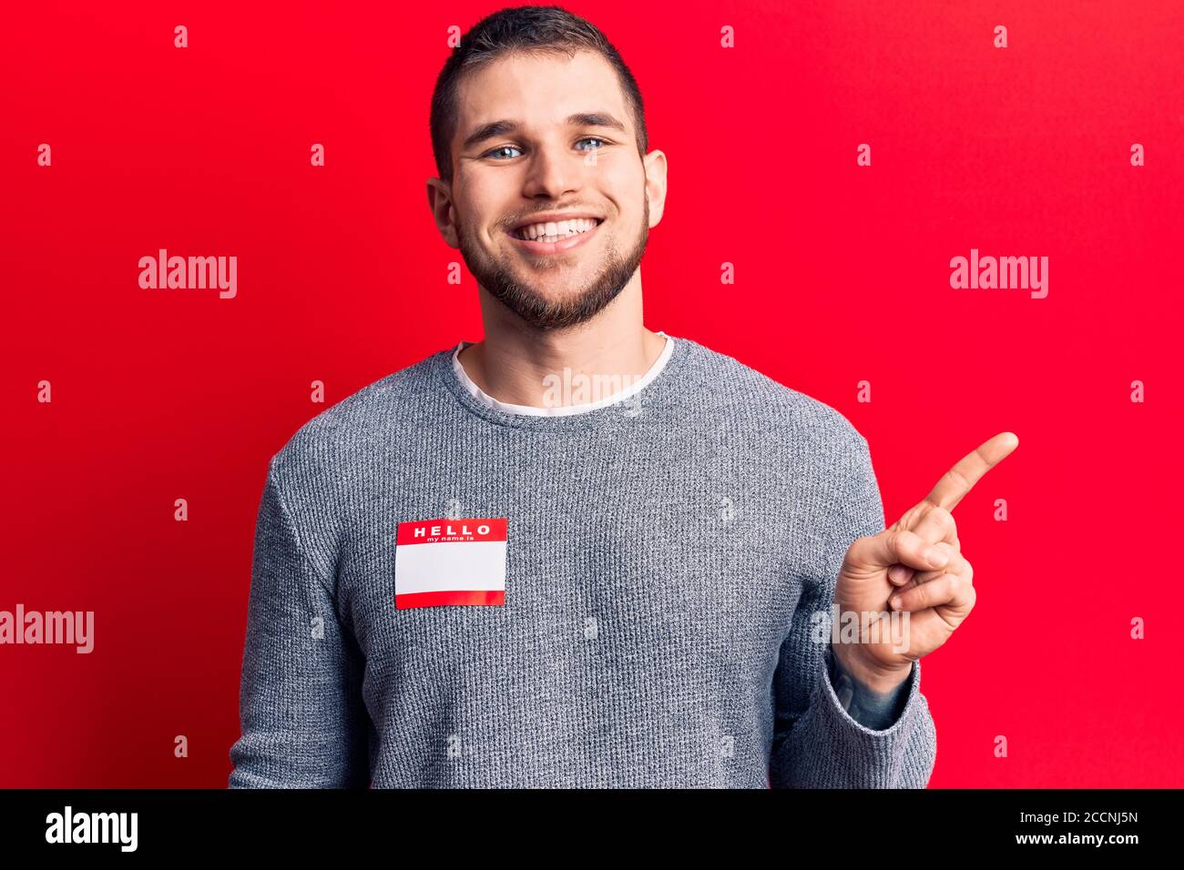 Young handsome man wearing hello my name is sticker smiling happy ...