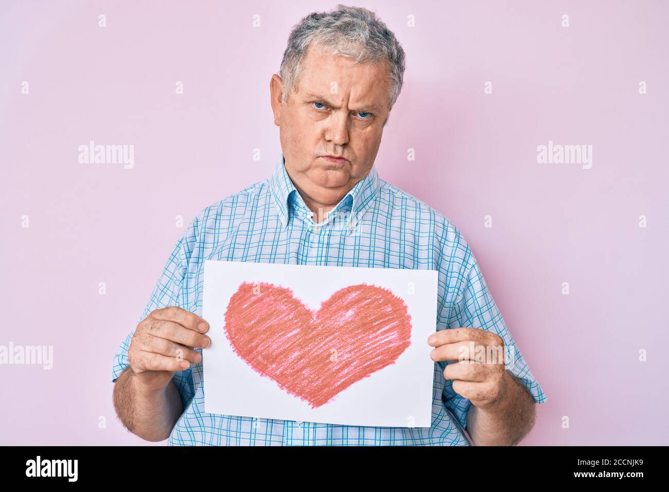 Senior grey-haired man holding heart draw depressed and worry for ...