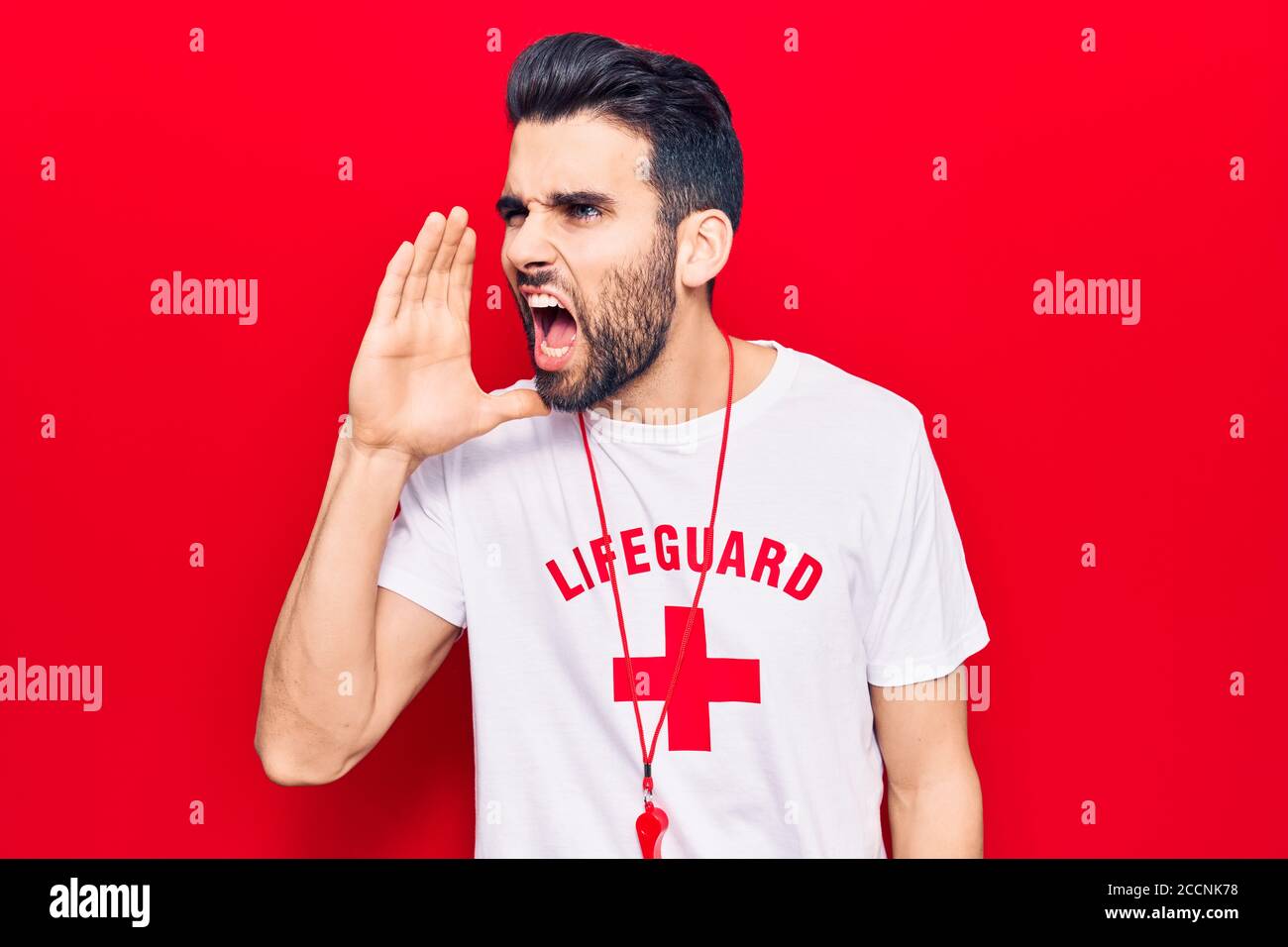 Young handsome man with beard wearing lifeguard t-shirt and whistle ...