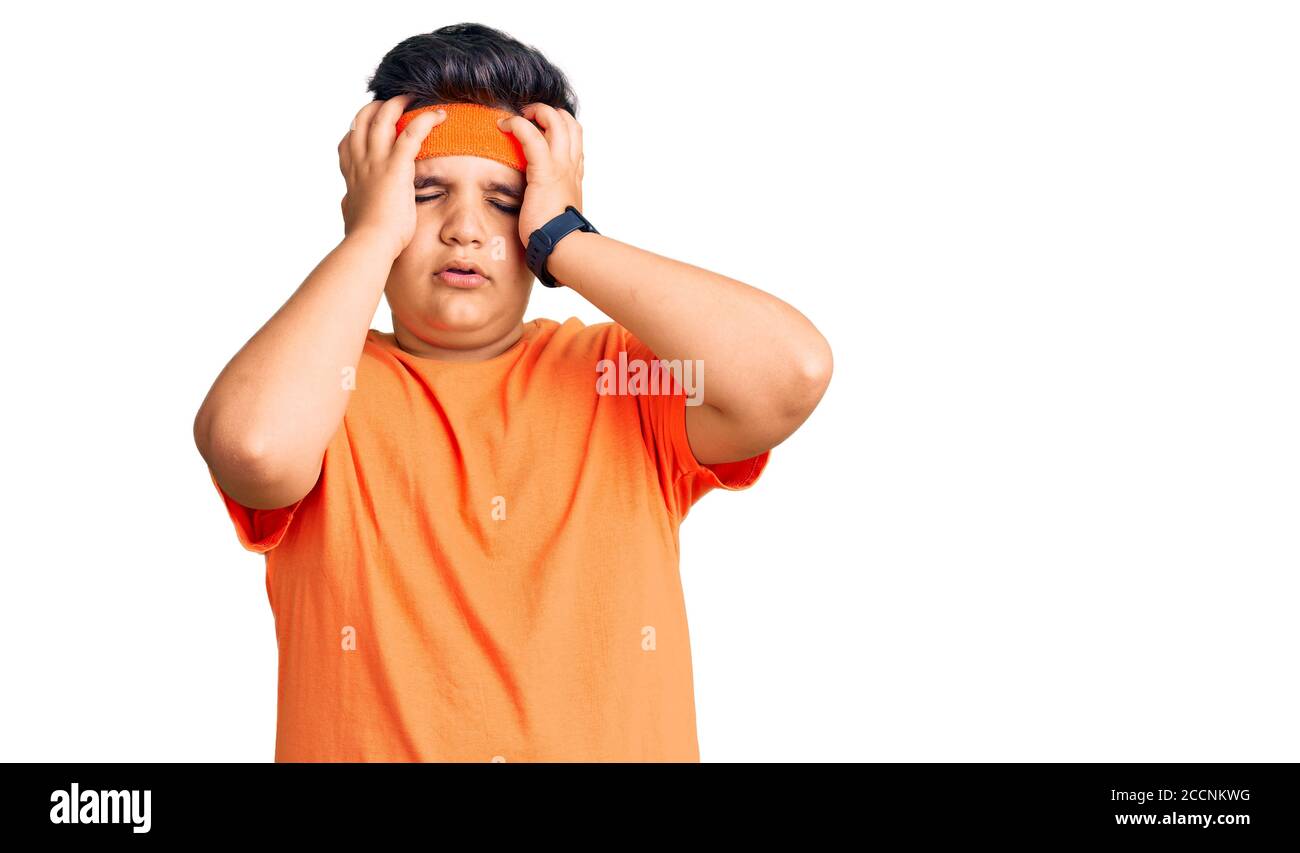 Little boy kid wearing sportswear suffering from headache desperate and ...