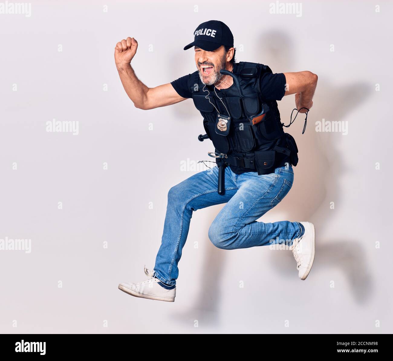 Middle age handsome man wearing police unifrom smiling happy. Jumping ...