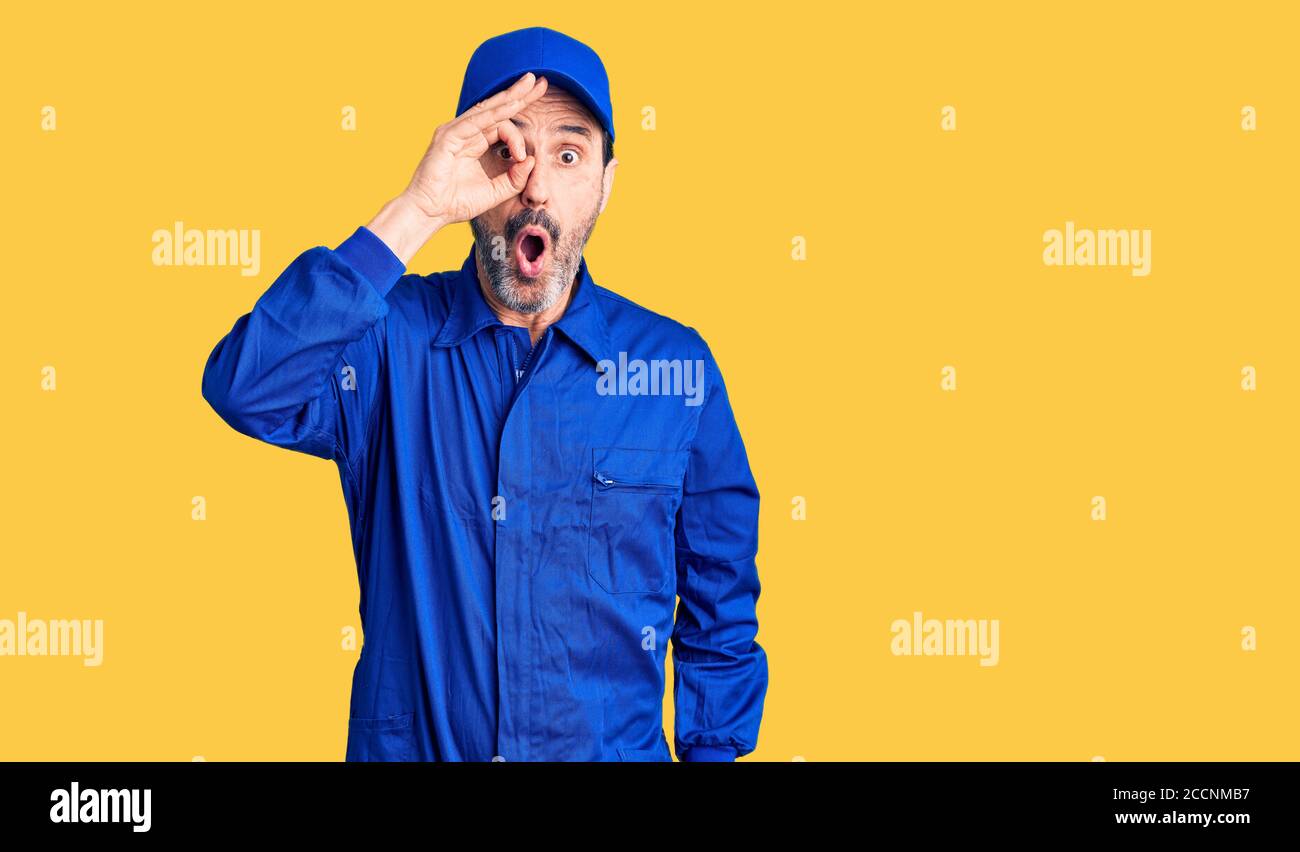 Middle age handsome man wearing mechanic uniform doing ok gesture ...