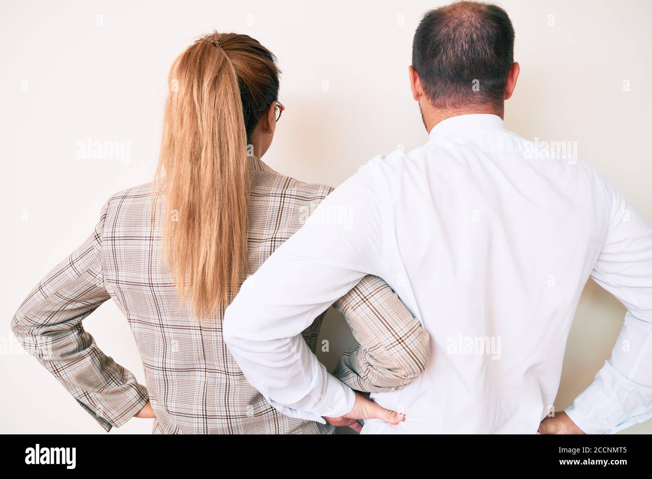 Beautiful couple wearing business clothes standing backwards looking ...