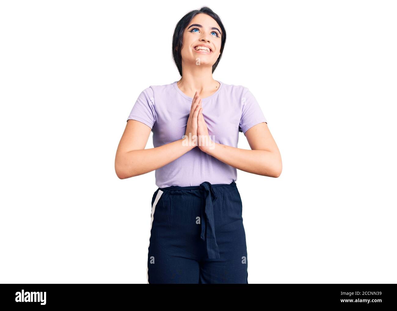 Brunette teenager girl wearing casual clothes begging and praying with ...