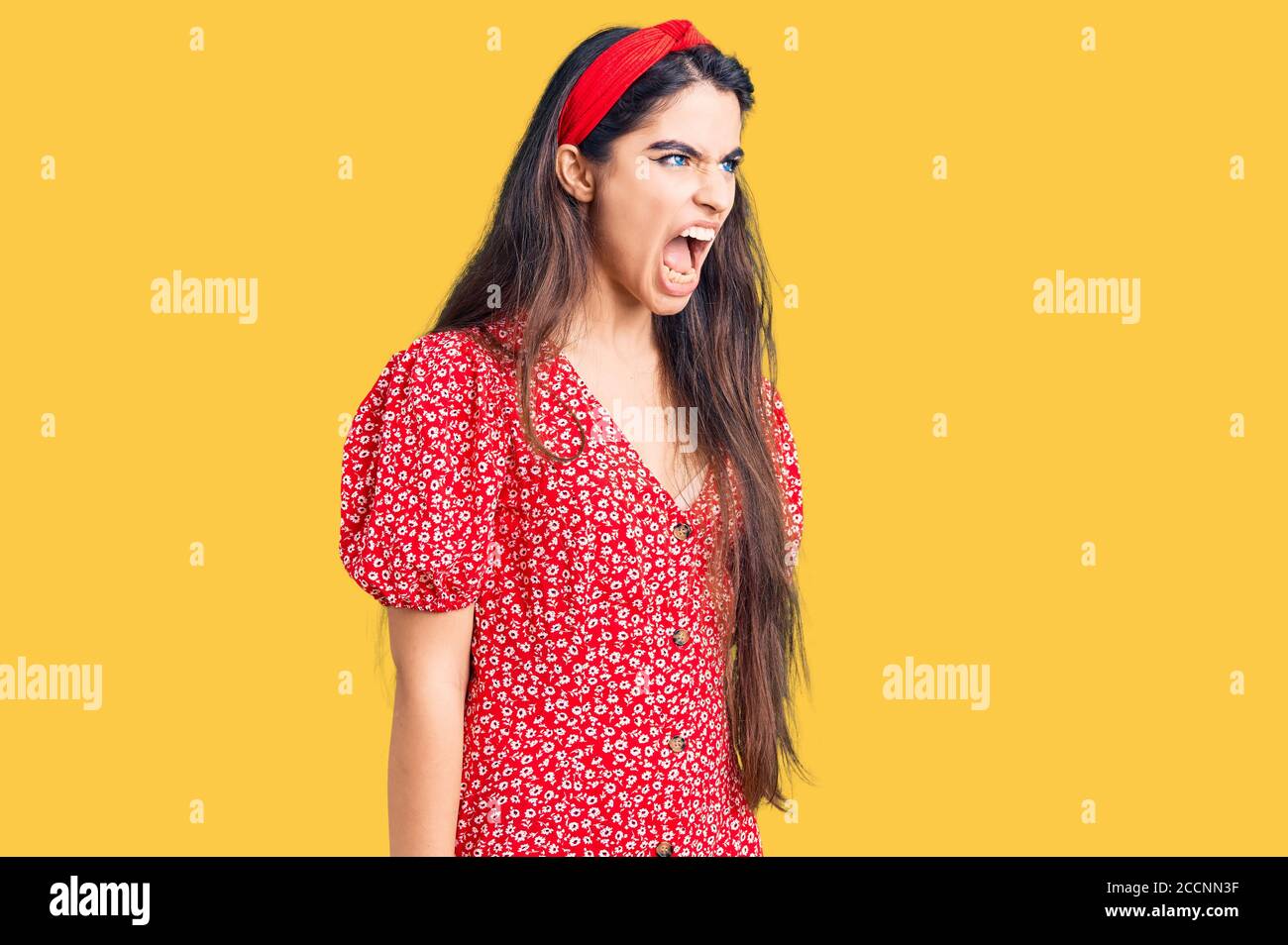 Brunette teenager girl wearing summer dress angry and mad screaming ...