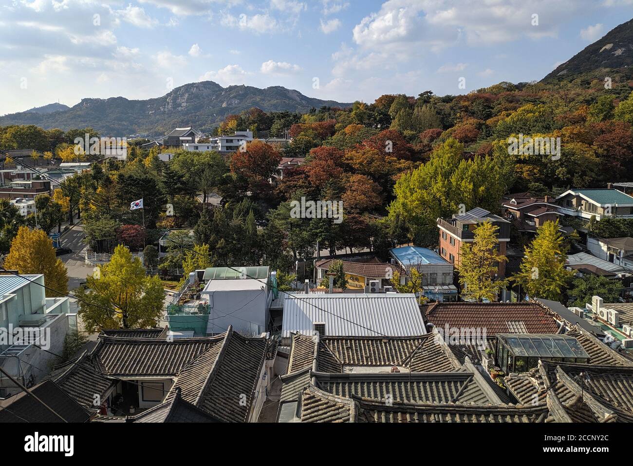 Traditional rooftops of a Hanok village. Forest and hills at the ...
