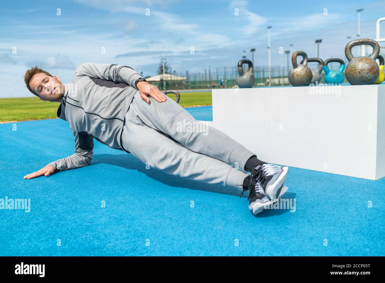 Planking fitness man doing side plank exercises at outdoor gym training ...