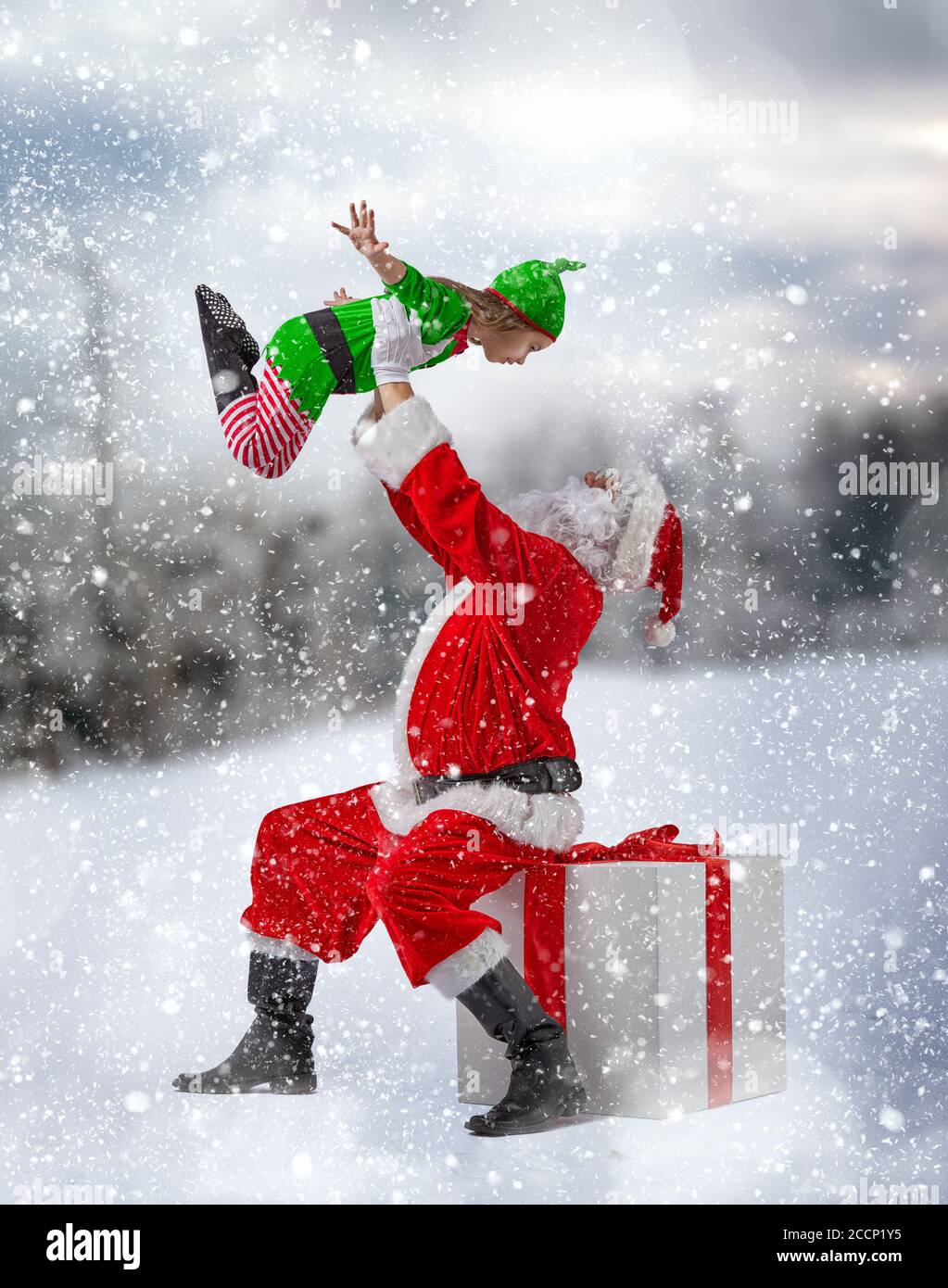 Jolly elf and Santa Claus play together Stock Photo - Alamy
