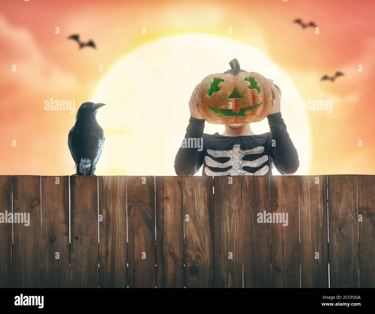 Happy Halloween! Cute little skeleton with pumpkin. Beautiful young ...