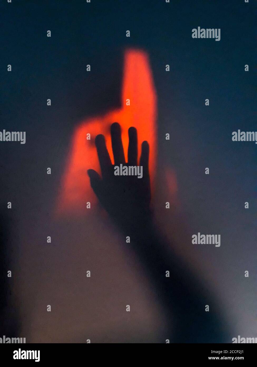 hand illuminated with natural sunlight casting shadow on wall in ...