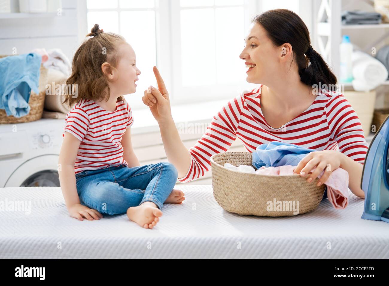 Beautiful young woman and child girl little helper are having fun and ...