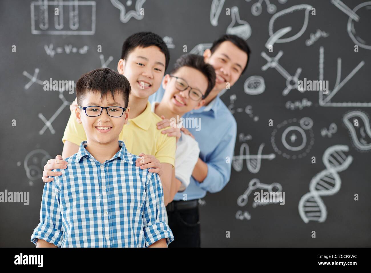 Teacher standing behind students hi-res stock photography and images ...